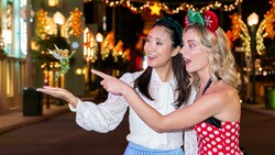 A Disney PhotoPass Magic Shot featuring 2 Guests looking at Tinker Bell ...
