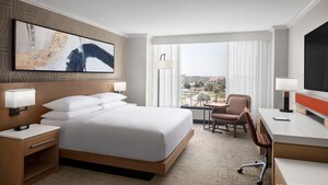A hotel guest room features a king size bed flanked by nightstands ...